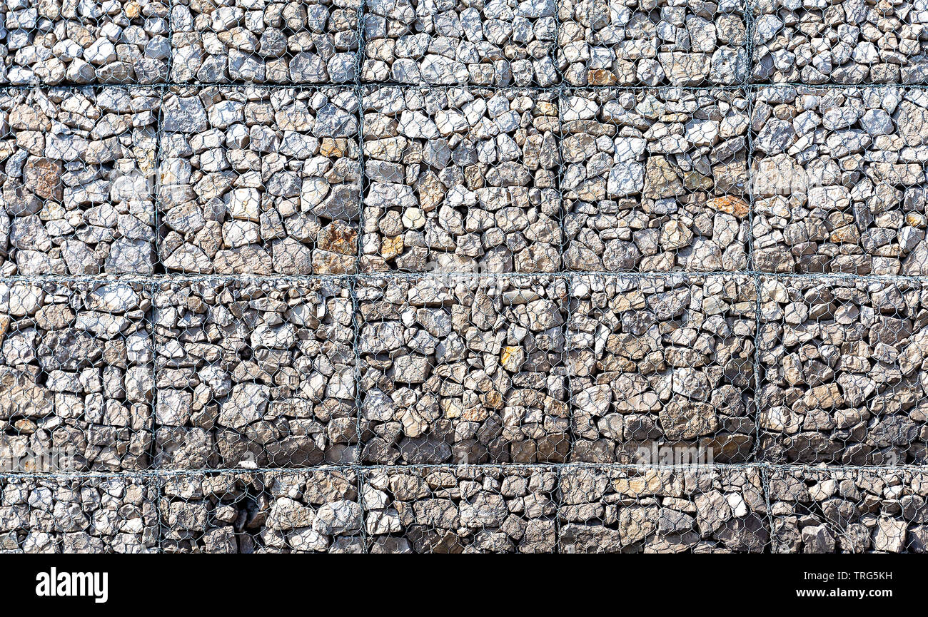 Stone wall with metal grid as background. Rock texture Stock Photo - Alamy