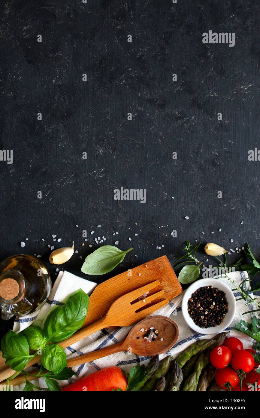 Wooden spoon and knife with ingredients on dark background. Top view ...