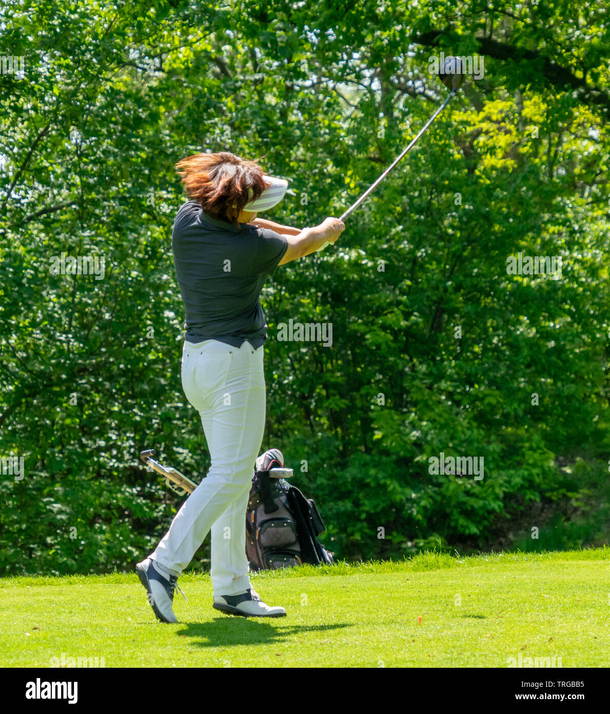 Braunschweig, Germany, May 18, 2019: Middle-aged woman hitting the golf ...