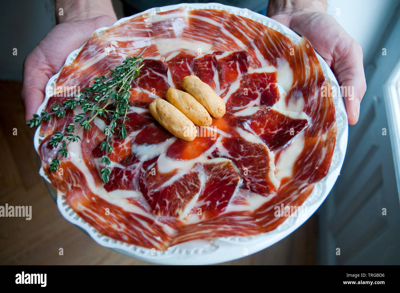 Man holding an Iberian ham dish. Spain Stock Photo - Alamy