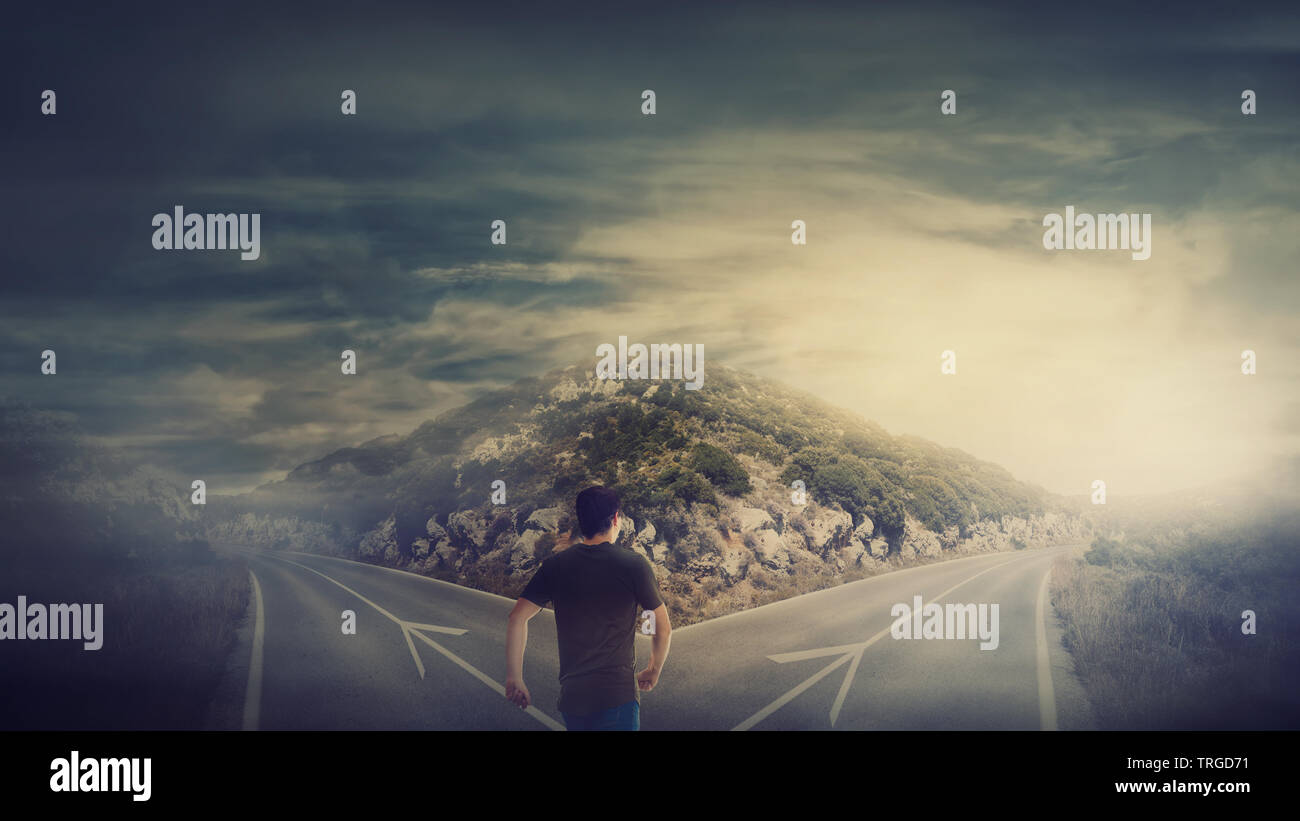 Rear view man walking in front of crossroad as road is split in two ...
