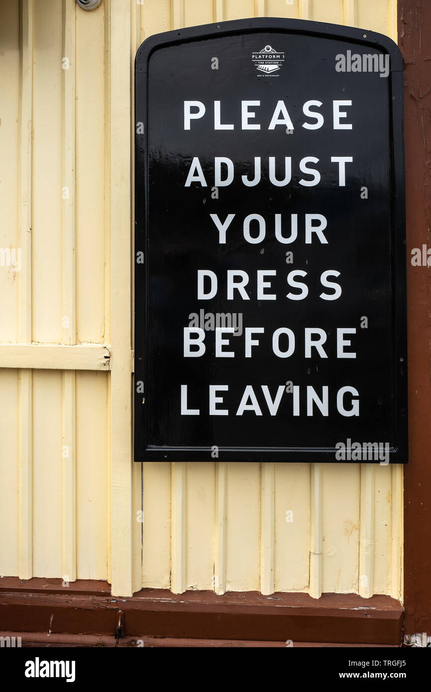 Please adjust your dress sign, Dartmouth, Devon, UK Stock Photo - Alamy