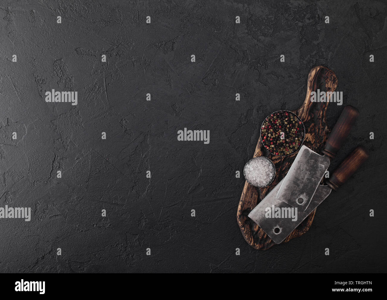 Vintage meat knife hatchet on vintage chopping board and black stone ...