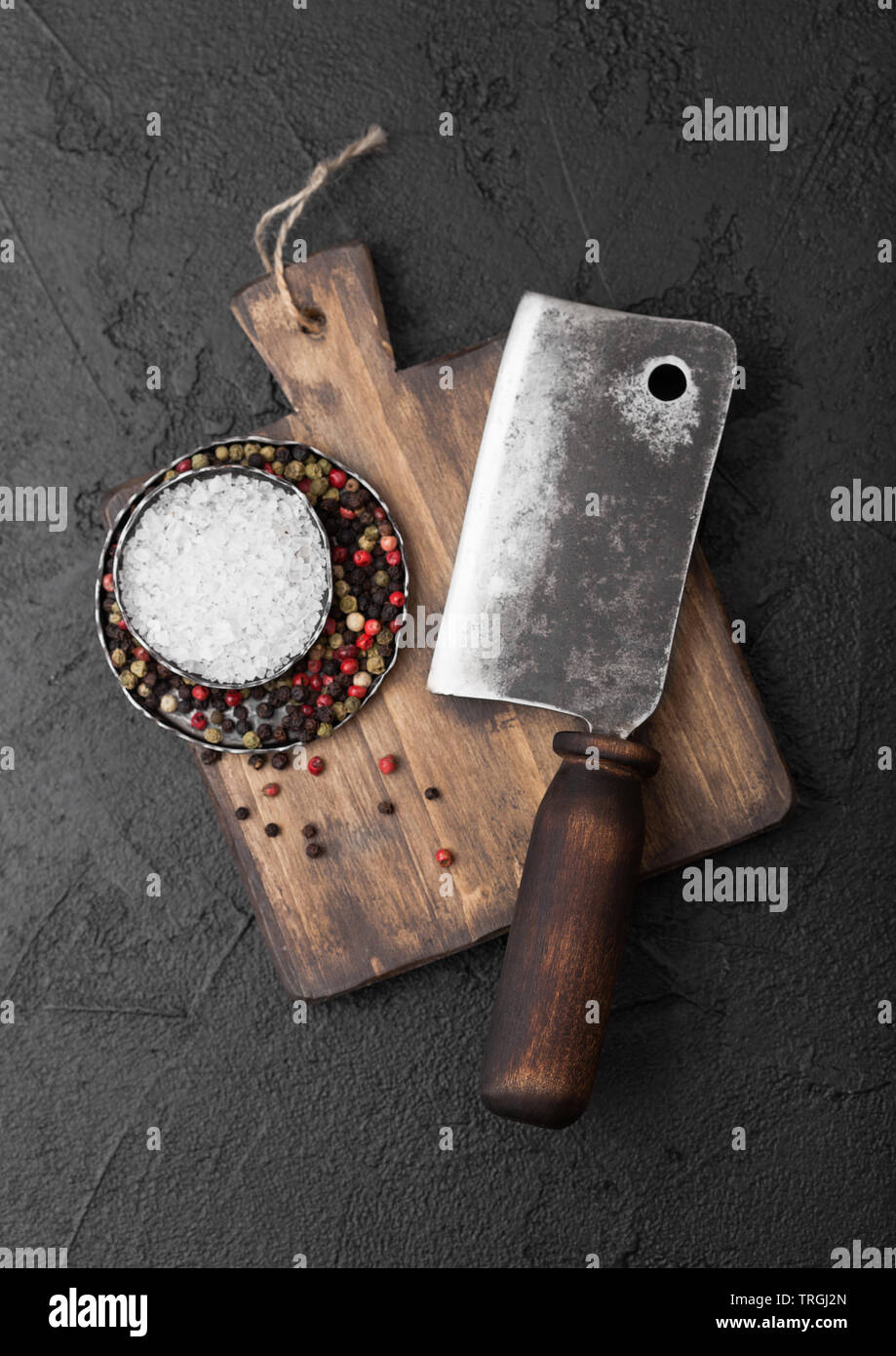 Vintage meat knife hatchet on vintage chopping board and black stone ...