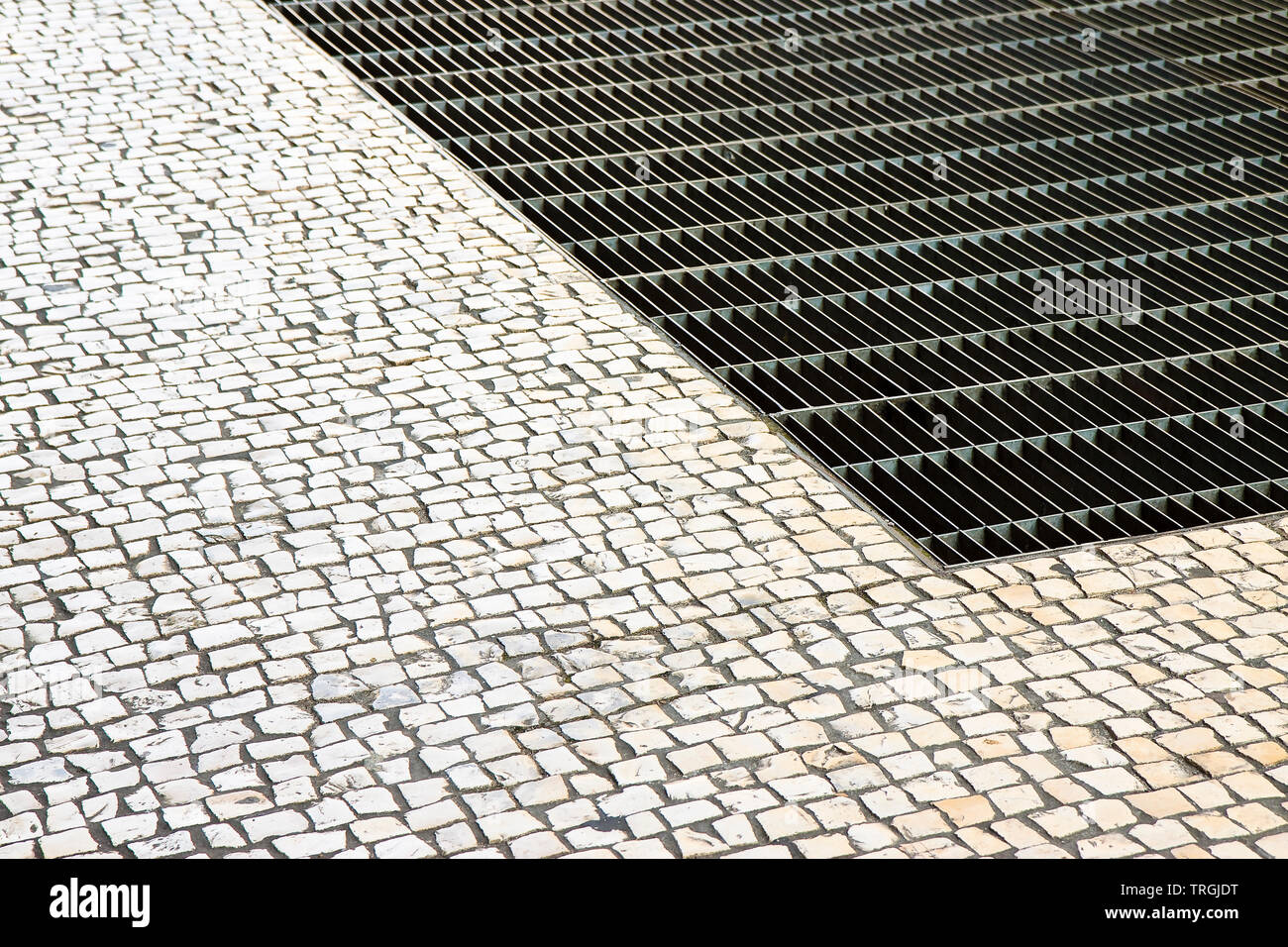 Ventilation iron grid on urban area with stone road - image with copy ...