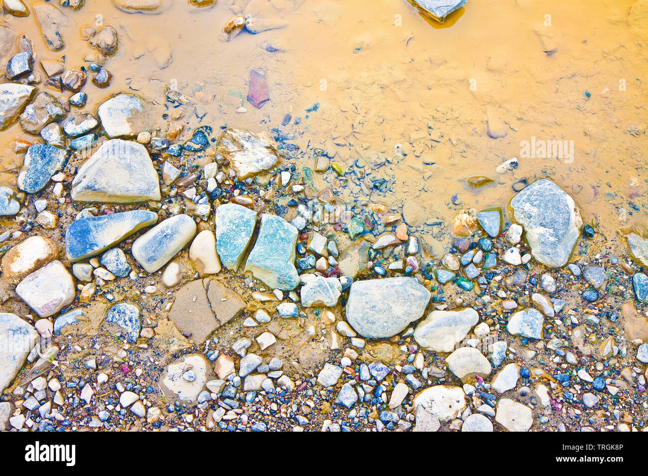 Puddle on rocky ground - background image Stock Photo - Alamy