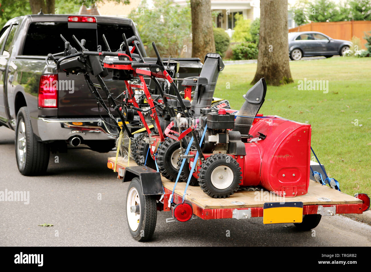 Three snowblowers on a trailer being towed by a truck Stock Photo - Alamy