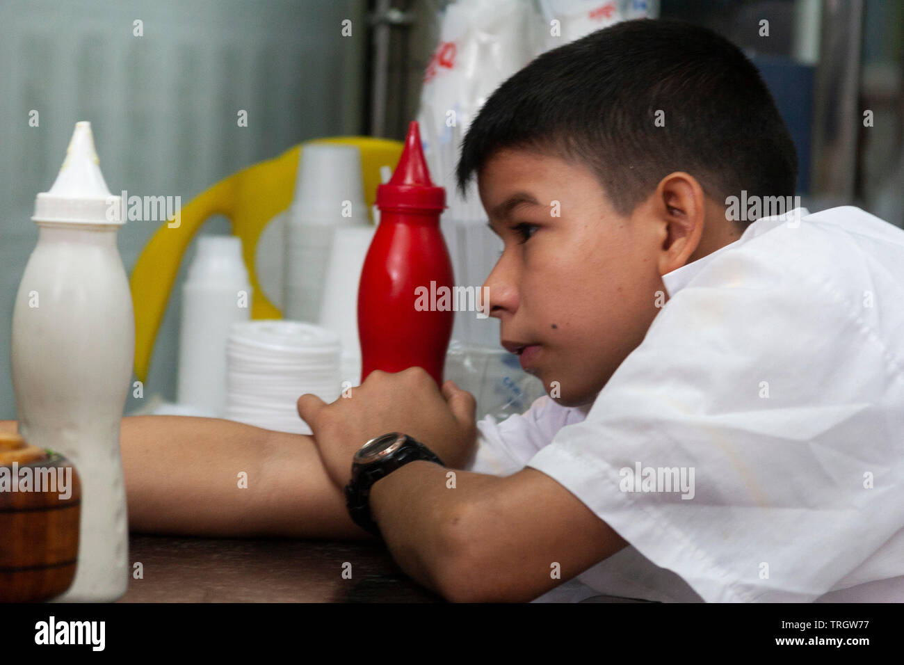 Caracas,Venezuela. Drowsy boy attending restaurant bar Stock Photo - Alamy