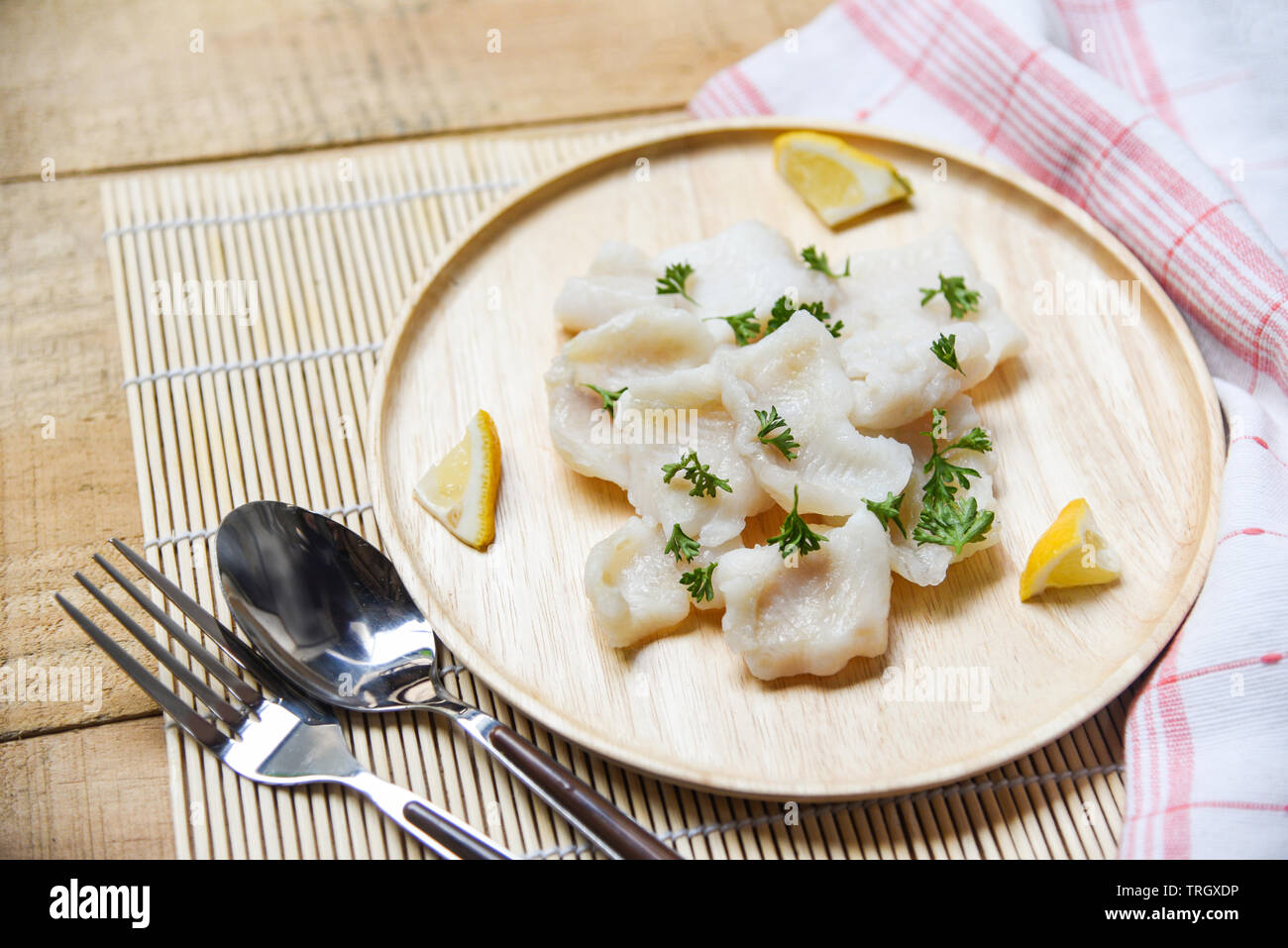 Japanese Cooked fish fillet piece with lemon and spices on wooden tray ...