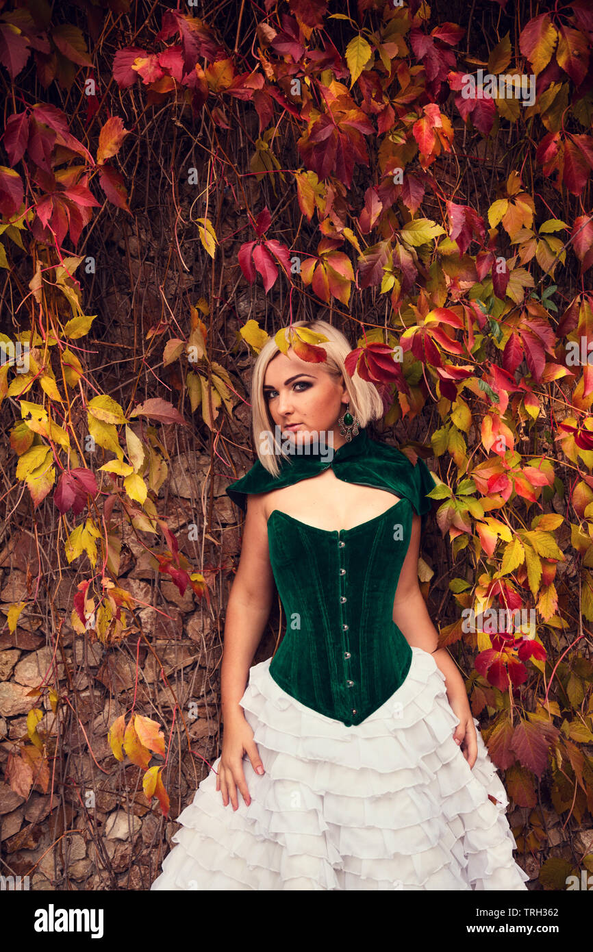 A woman like a princess in an vintage dress in fairy park. Mysterious ...