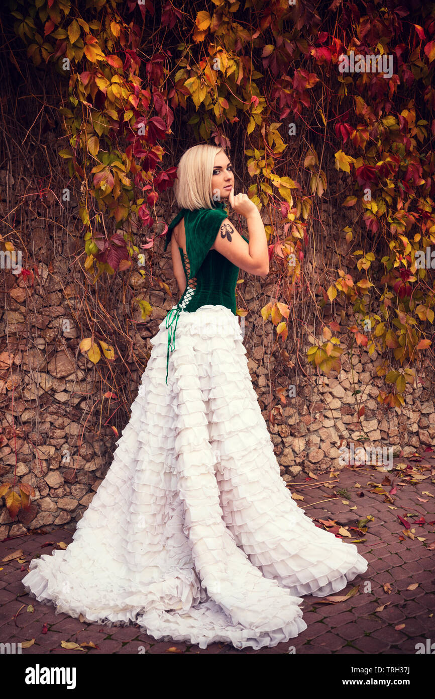 A woman like a princess in an vintage dress in fairy park. Mysterious ...