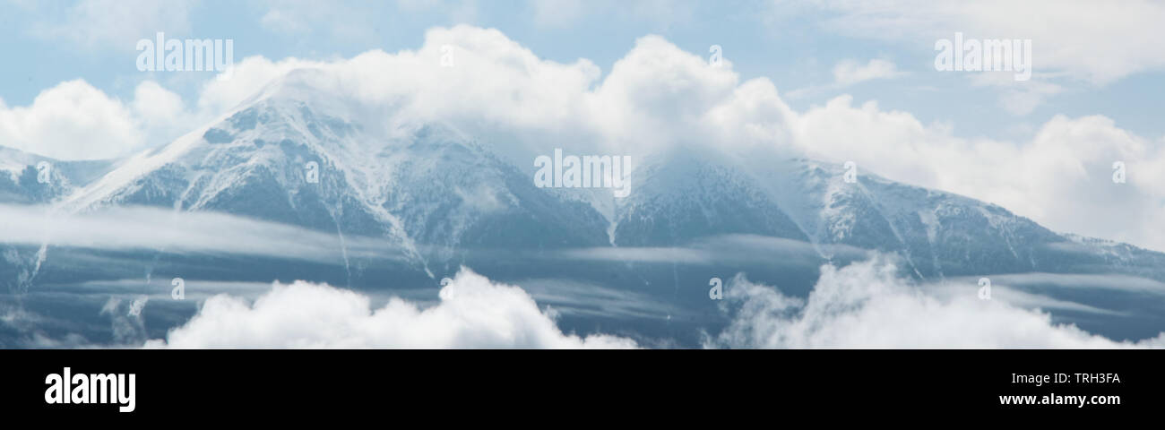Cloudy snowy Alps peaks. Foggy mountain landscape Stock Photo - Alamy