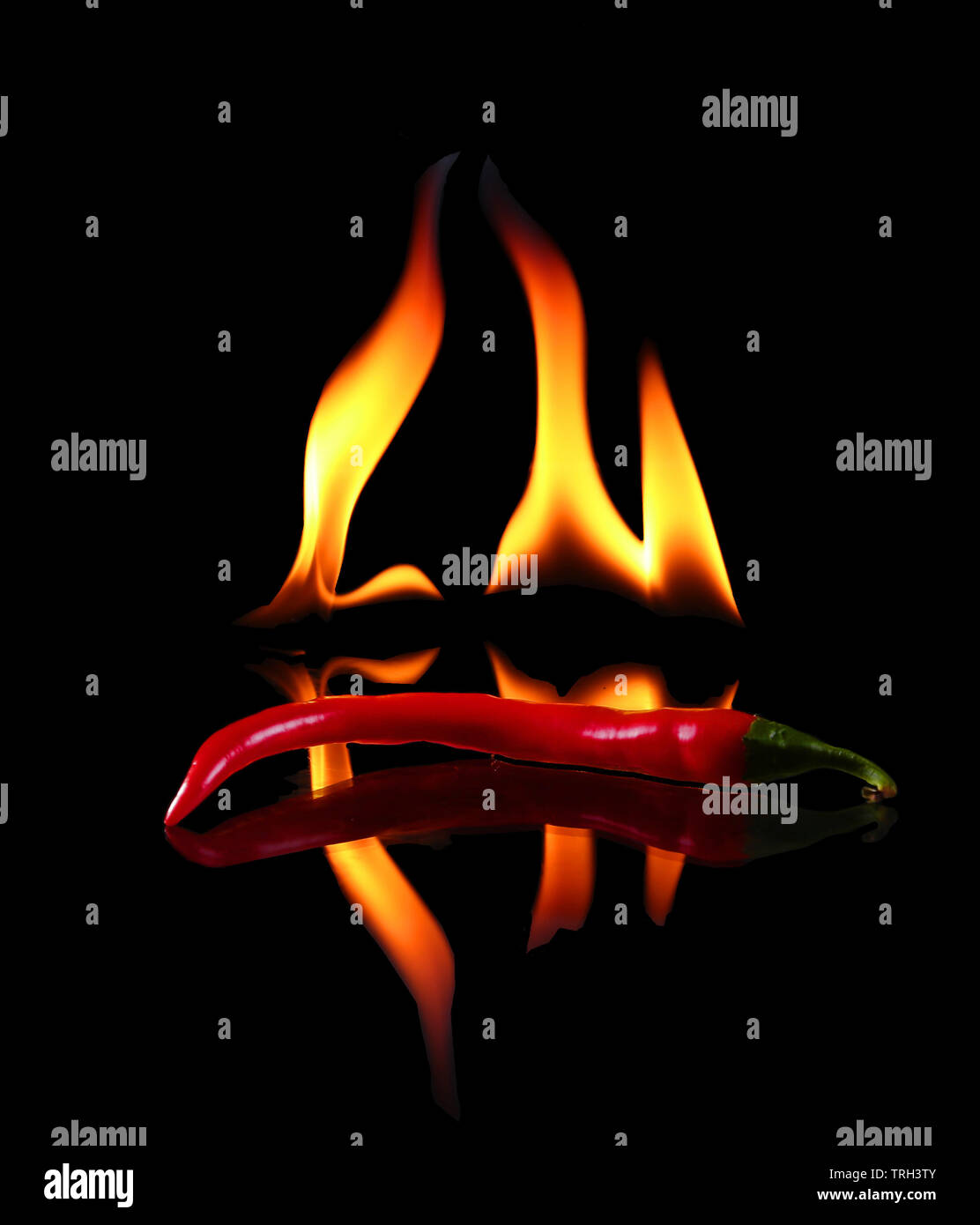 Hot pepper with flame on black background Stock Photo - Alamy