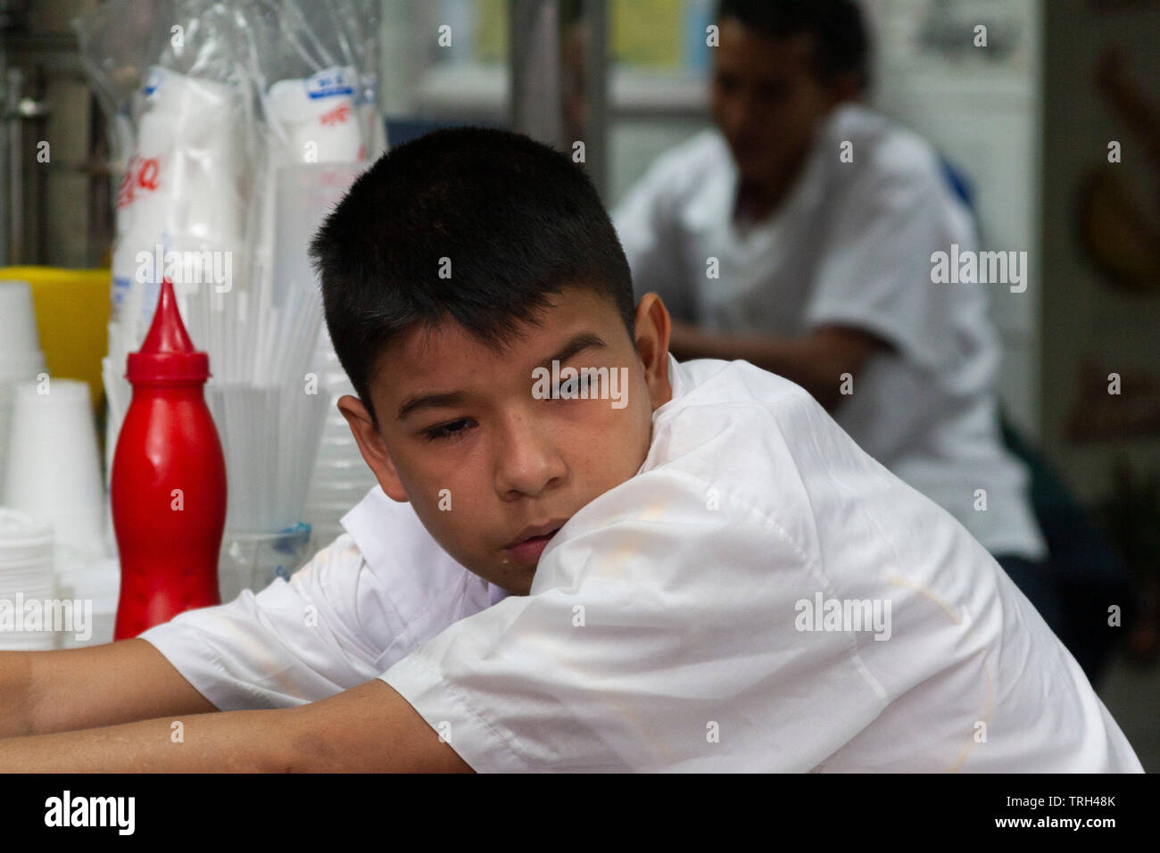 Caracas,Venezuela. Drowsy boy attending restaurant bar Stock Photo - Alamy
