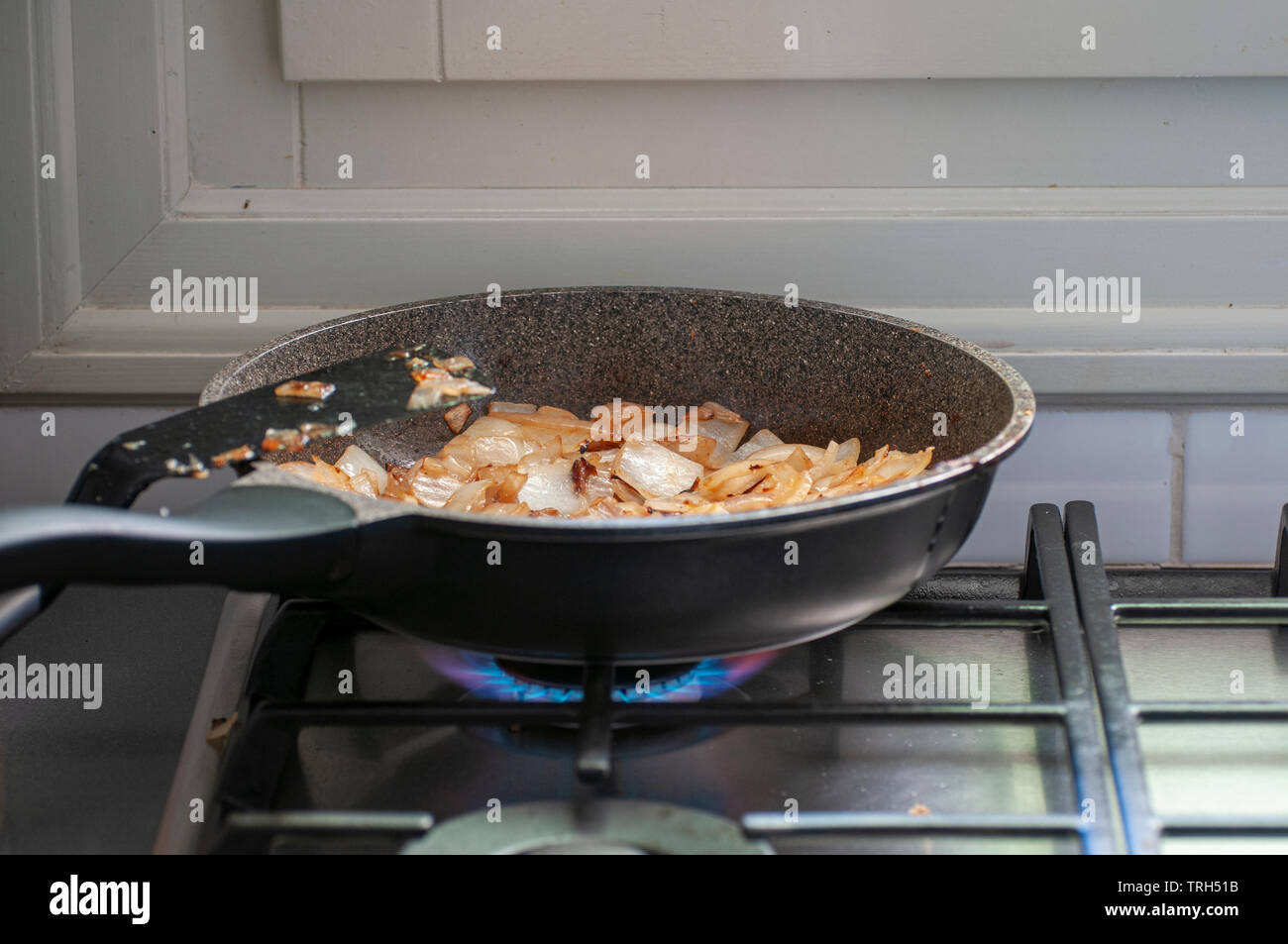 Home cooking. Onions frying in a frying pan on a stove at home Stock ...