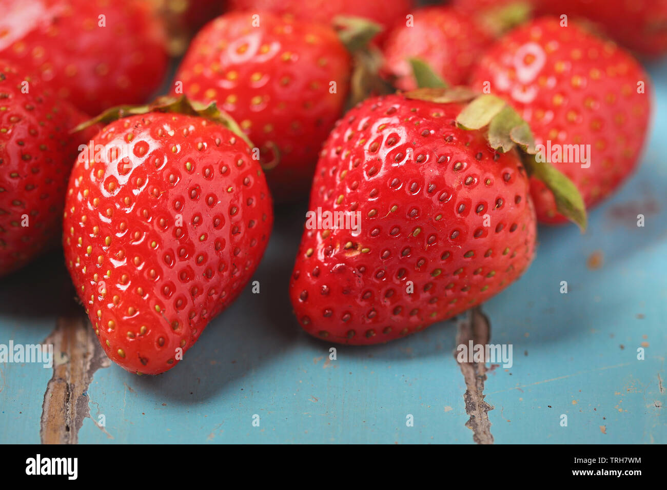 Imperfect fresh organic strawberries on blue rustic wooden background ...