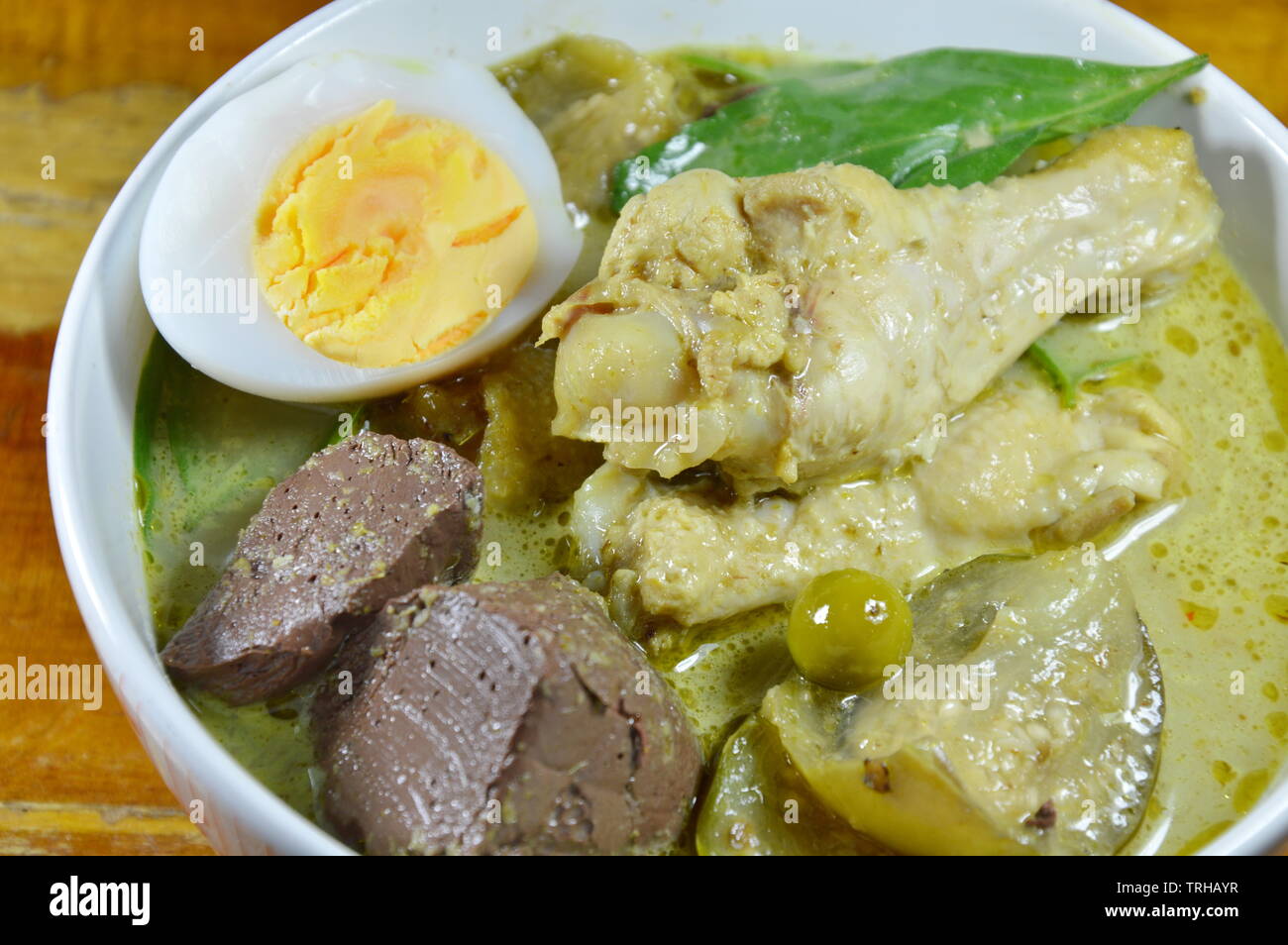 spicy chicken leg in green curry topping boiled egg on bowl Stock Photo ...