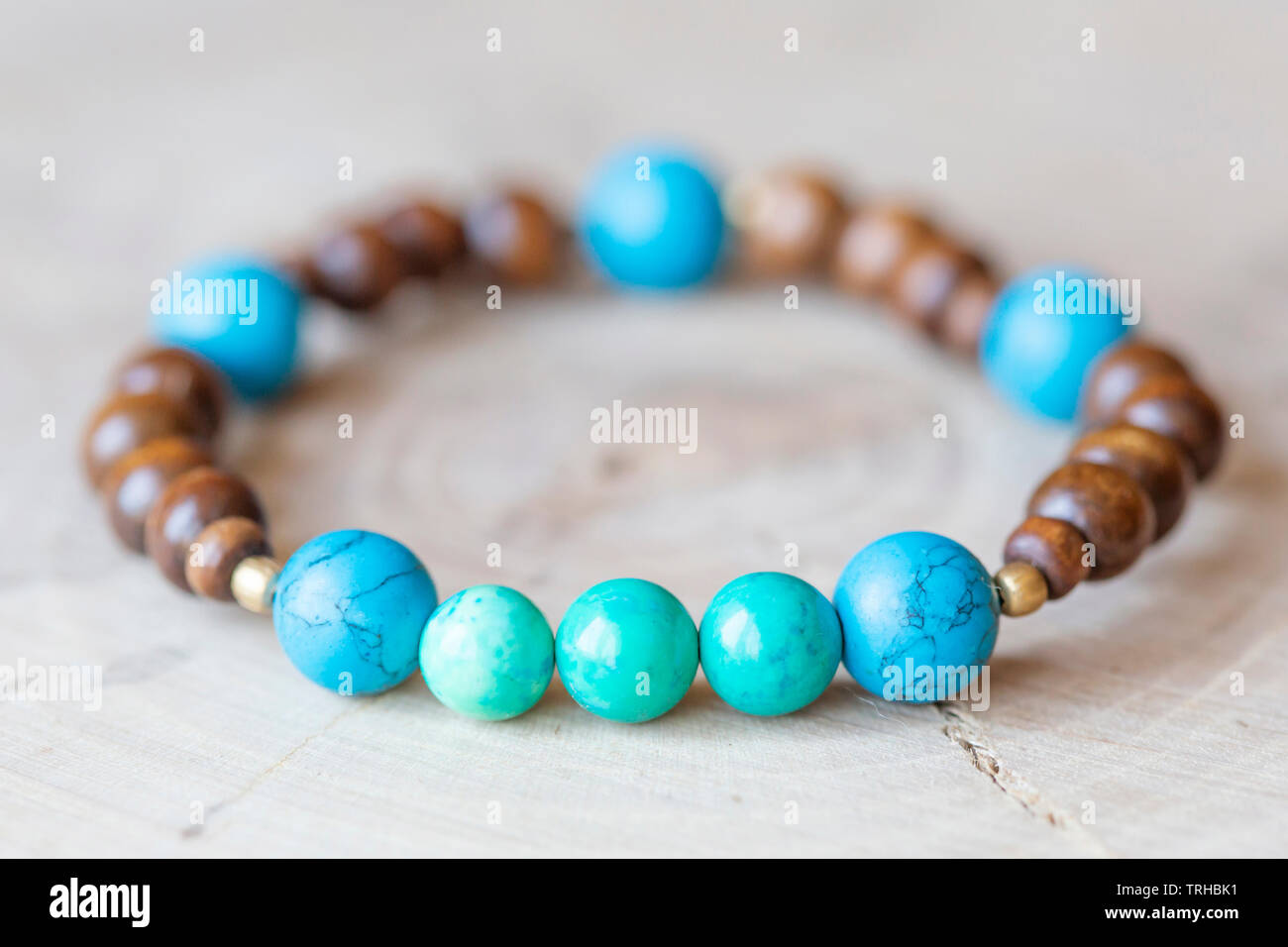 Mineral stone turquoise bead bracelet on natural wooden background ...