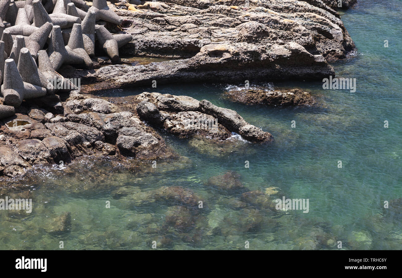Rocky ocean coast with breakwater concrete blocks structures. Keelung ...