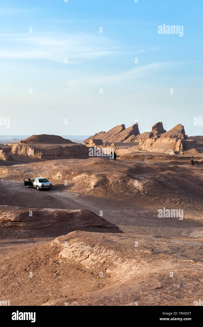Tourists watch the sunset over yardangs, called kuluts in Iran, in the ...