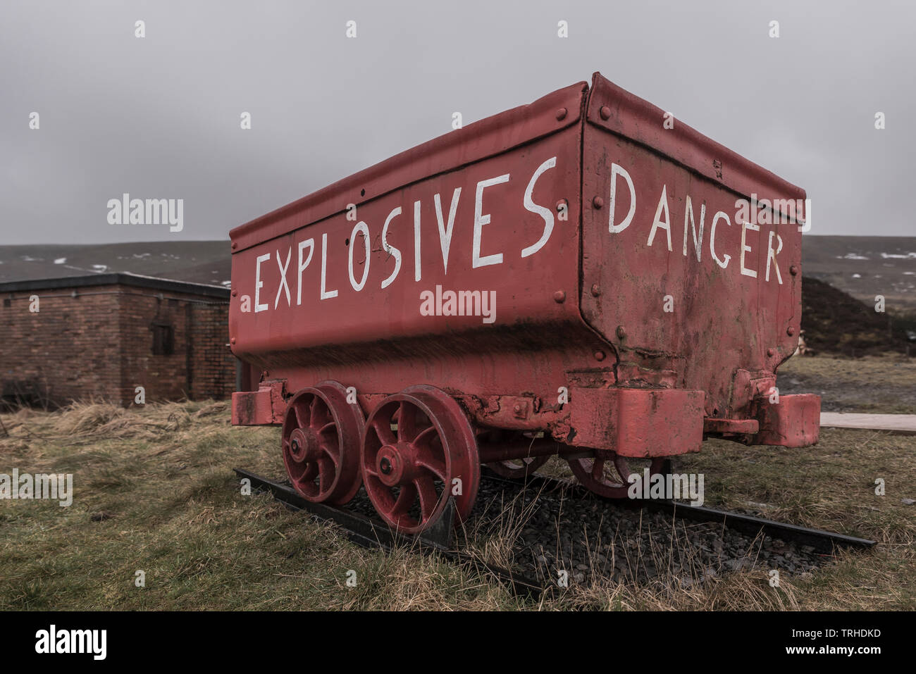 A bright red, weathered, mine cart, used to carry explosives to the ...