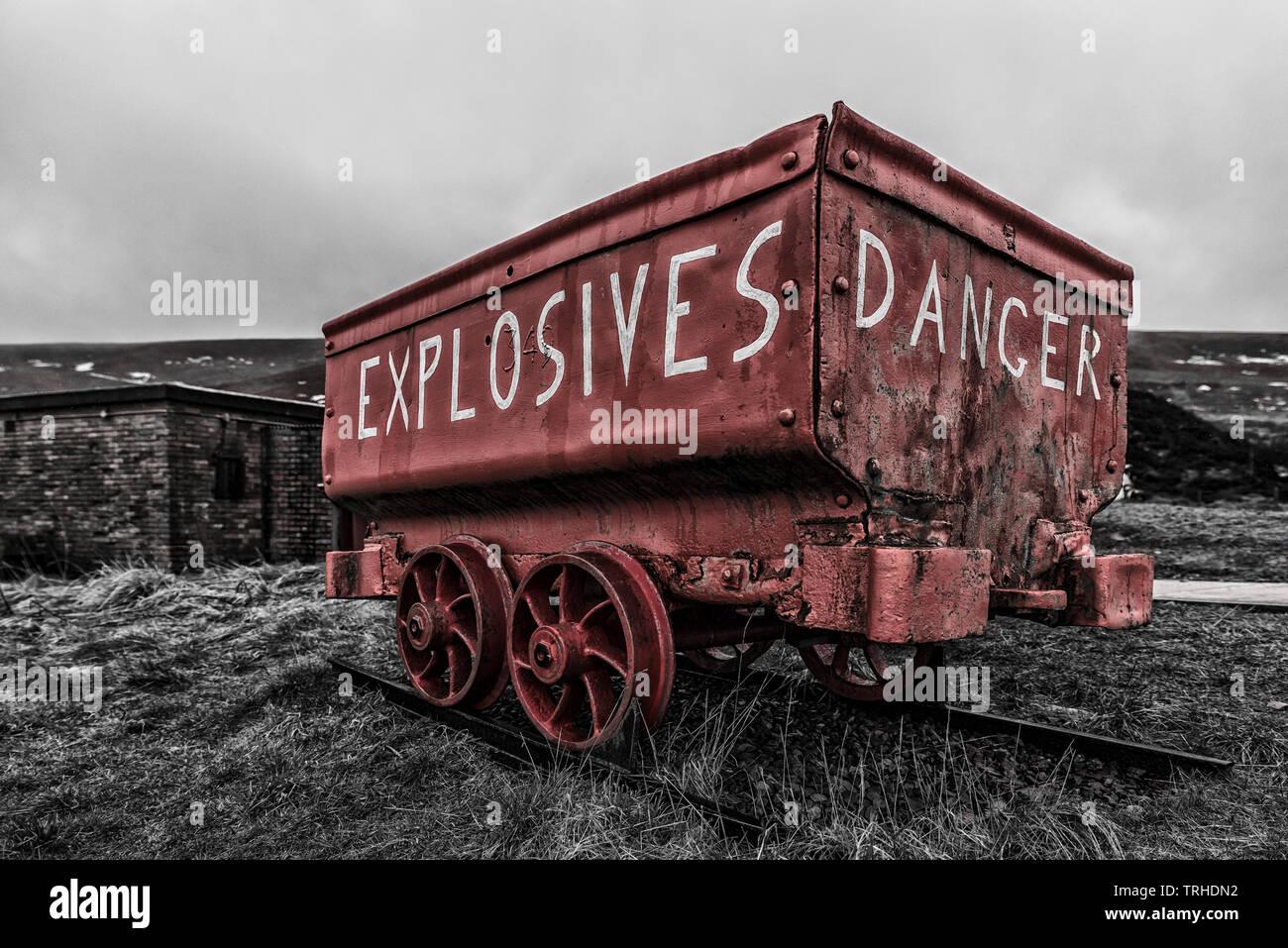 A bright red, weathered, mine cart, used to carry explosives to the ...