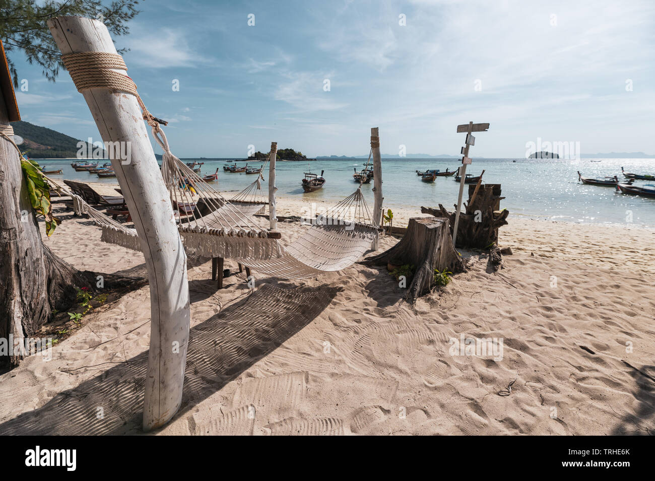 Rope cradle swing hanging on wood on the beach with wooden boat in ...