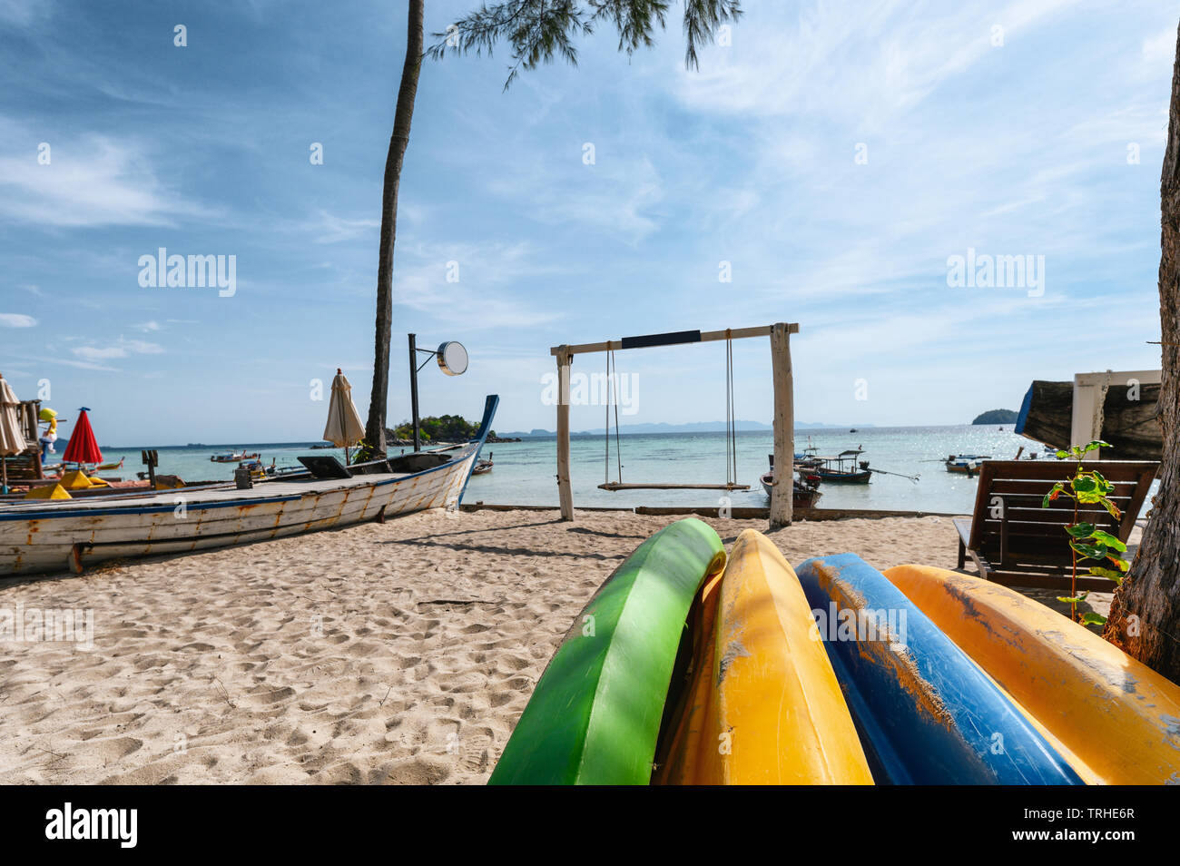 Colorful surfboard with wooden swing on the beach in tropical sea at ...