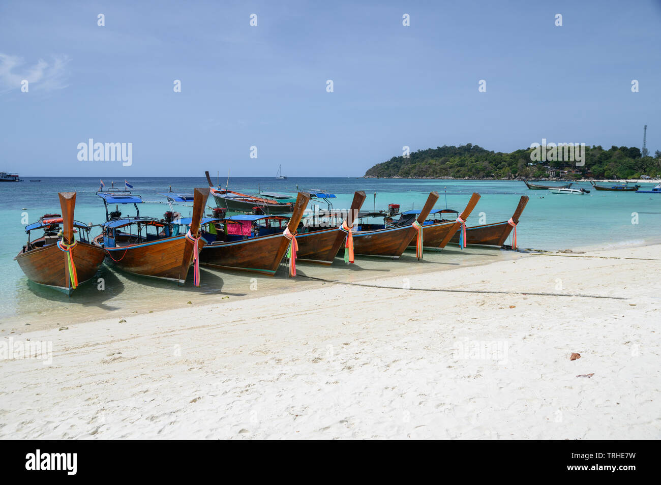 Long-tail wooden boats anchored on white beach in tropical sea at lipe ...