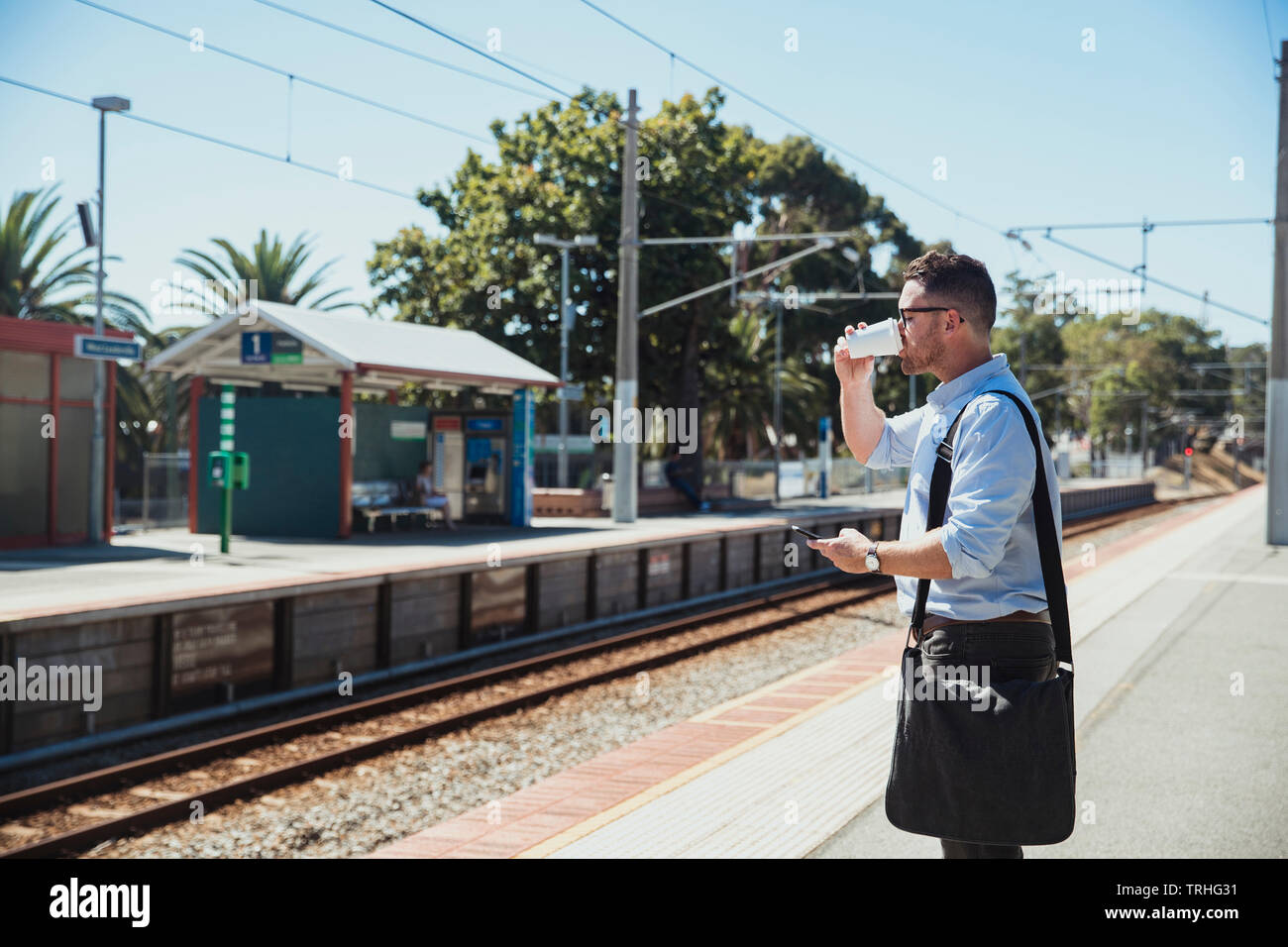 A side-view shot of a mid-adult caucasian businessman waiting at a ...