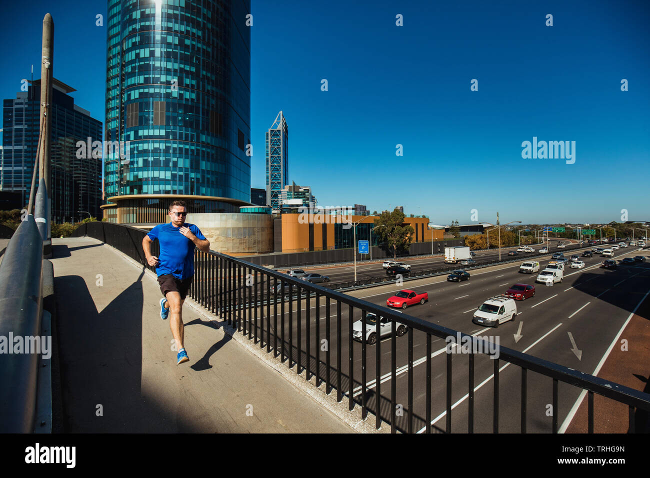A front-view shot of a caucasian mid-adult man jogging in the city on a ...