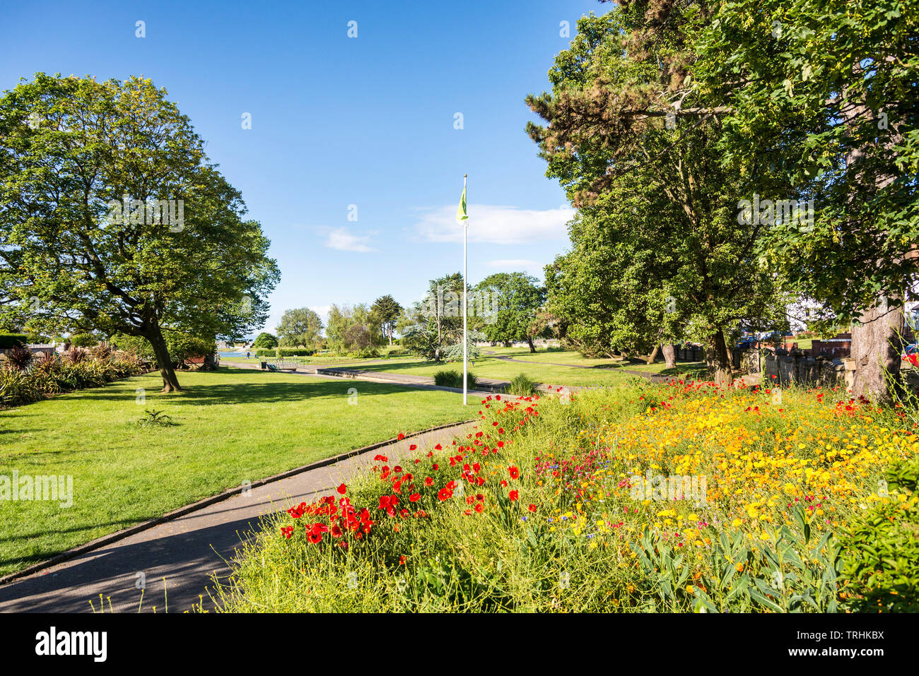 A path leads into attractive public gardens on a bright sunny morning ...