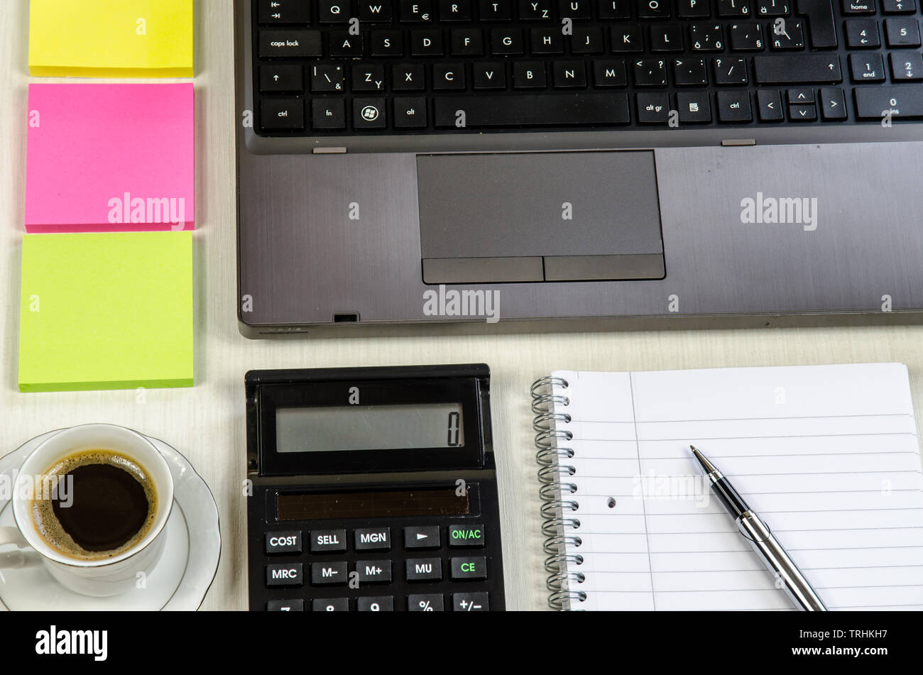 tidy office table with laptop, pen, notepad,coffee cup and colorful ...