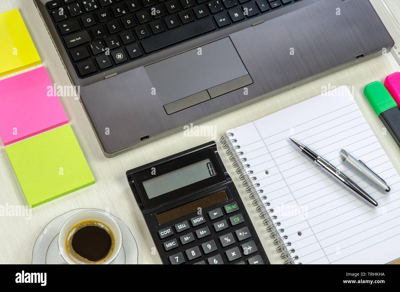 tidy office table with laptop, pen, notepad,cup of coffee and colorful ...