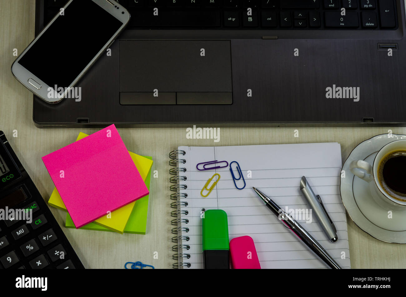 tide office table with laptop, pen, notepad,cup of coffee, smartphone ...
