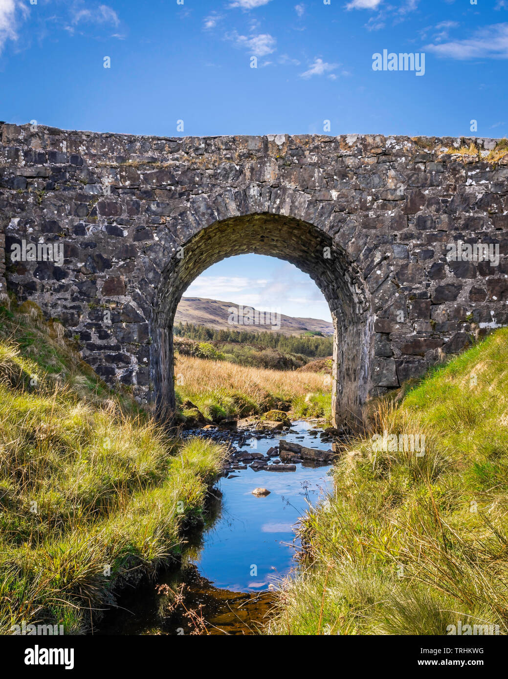 Blue sky above old stone bridge over stream on Isle of Skye.Idyllic ...
