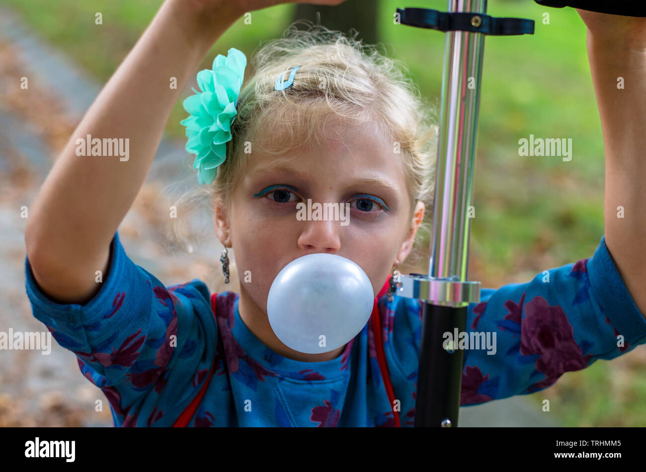 lovely little blond girl blowing chewing gum bubble Stock Photo - Alamy