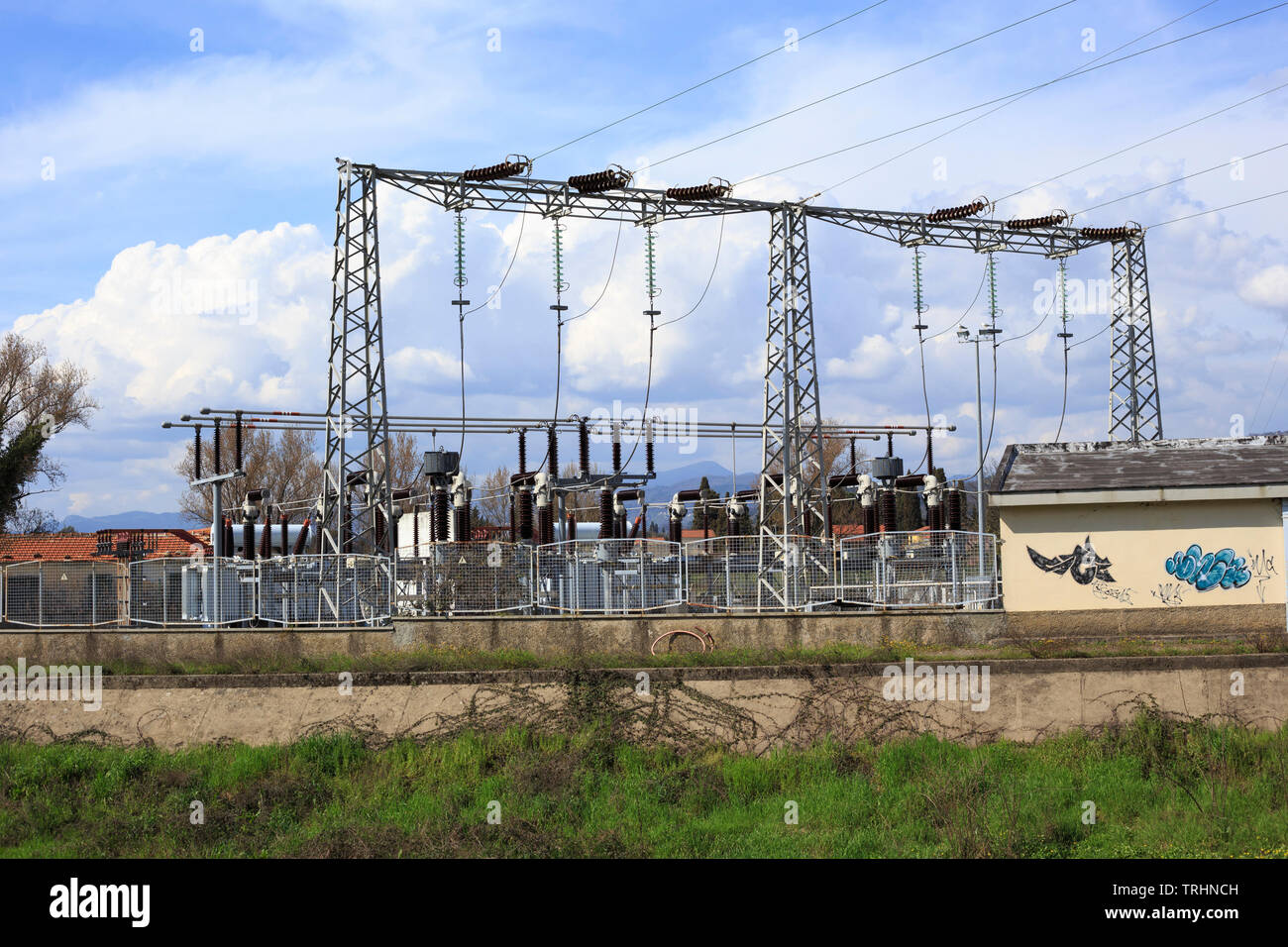 A transformer station in the foreground and electricity pylons in the ...