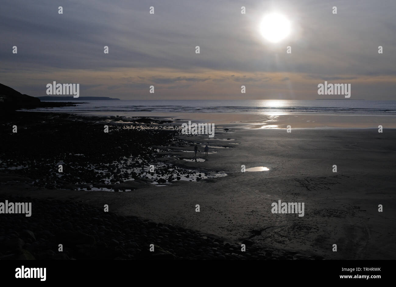 Evening sunlight lights up rock pools on the beach at Westward Ho ...