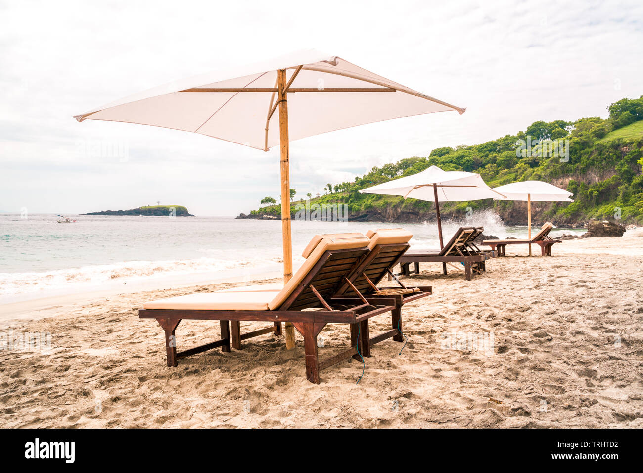 Empty sunbeds waiting for tourists on Virgin beach or Pasir Putih or ...