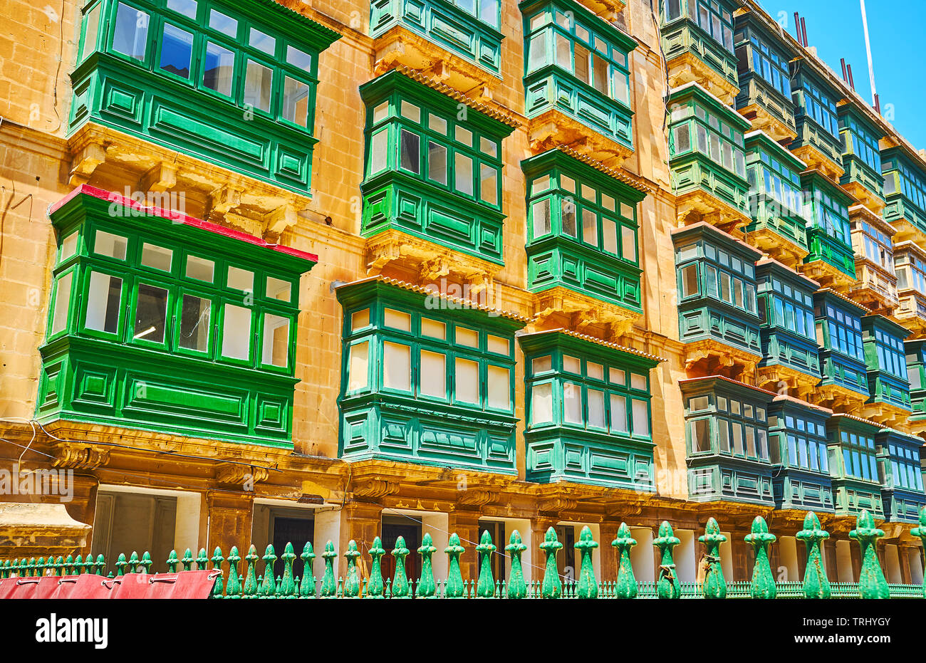 The long residential house wall with bright green Maltese balconies ...