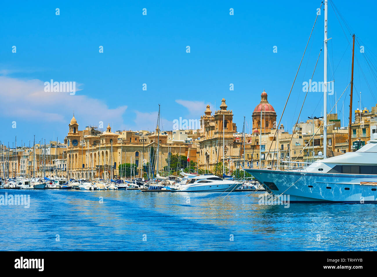 The skyline of Birgu with sails of yachts, clock tower of Maritime ...