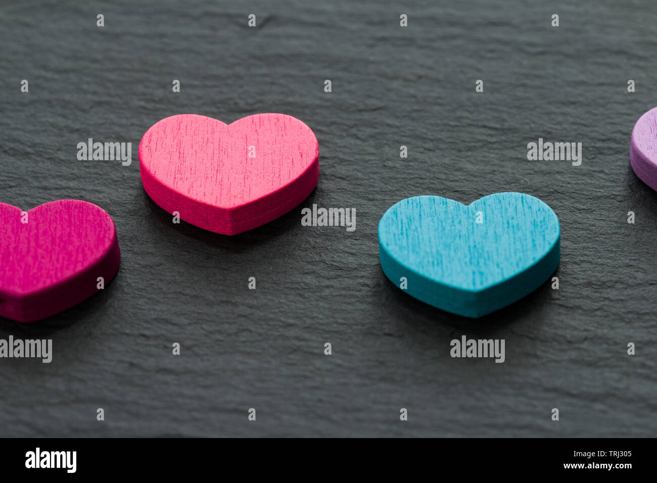 Slate stone board with colorful hearts . Dark stone background with ...