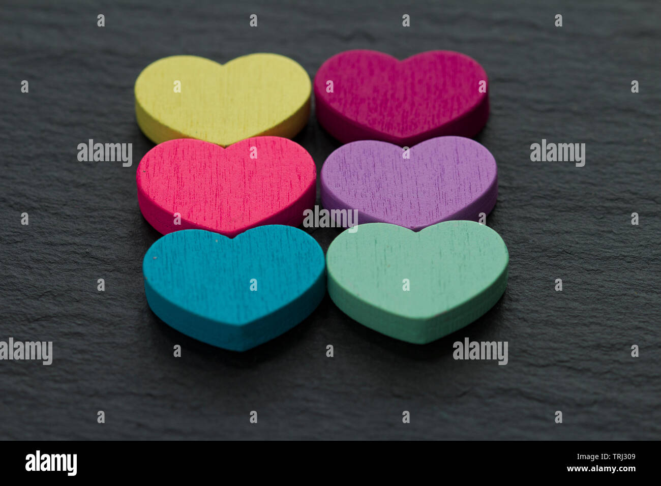 Slate stone board with colorful hearts . Dark stone background with ...