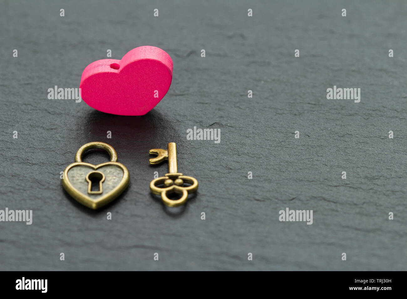 Heart-shaped padlock with key on a slate stone background . key from ...