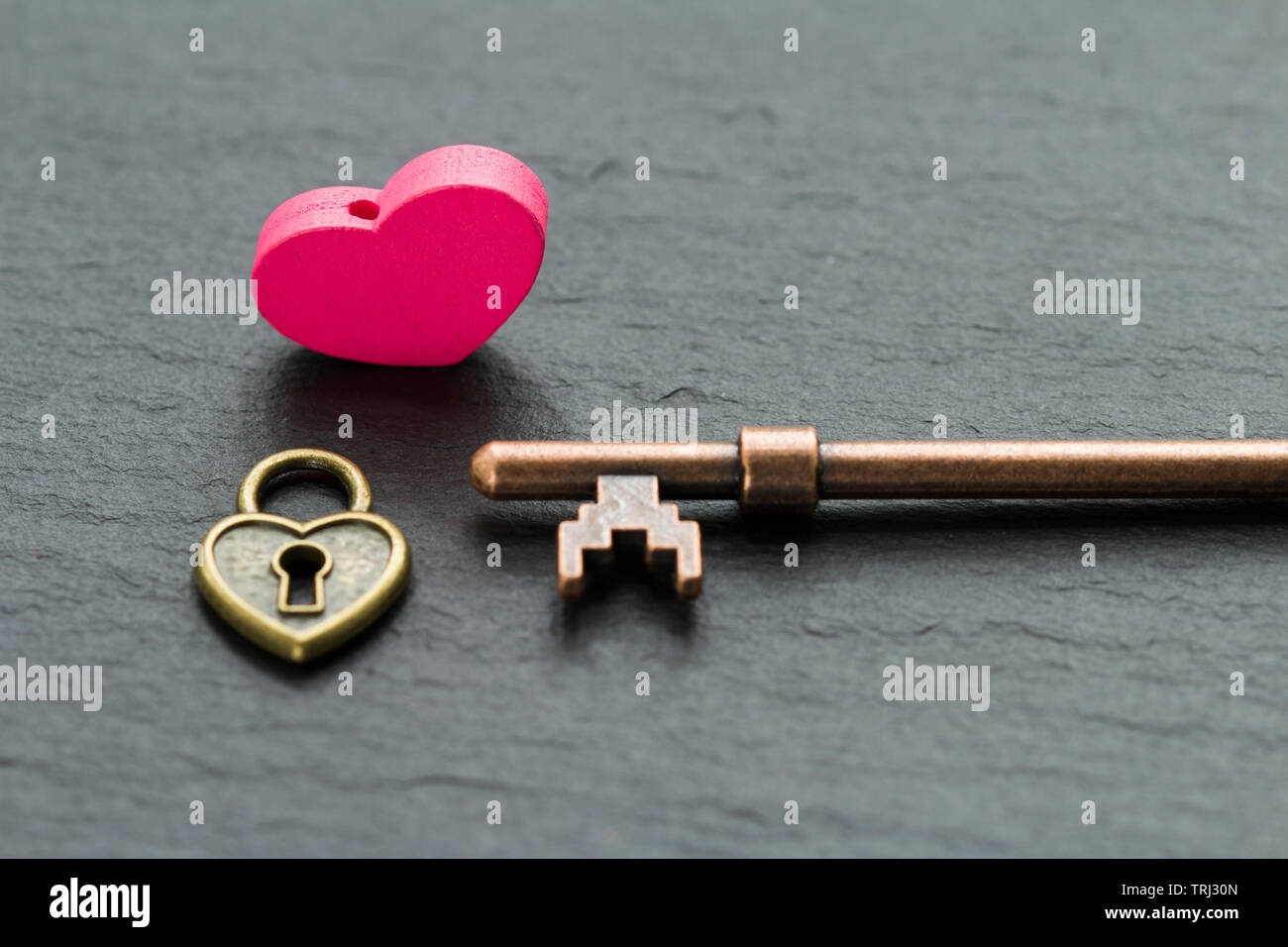 Heart-shaped padlock with key on a slate stone background . key from ...