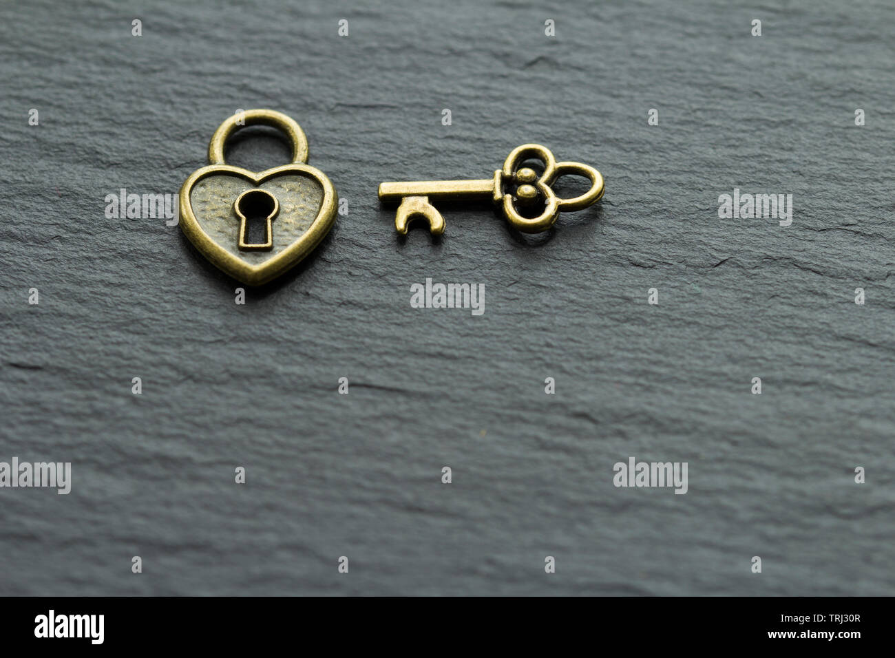 Heart-shaped padlock with key on a slate stone background . key from ...