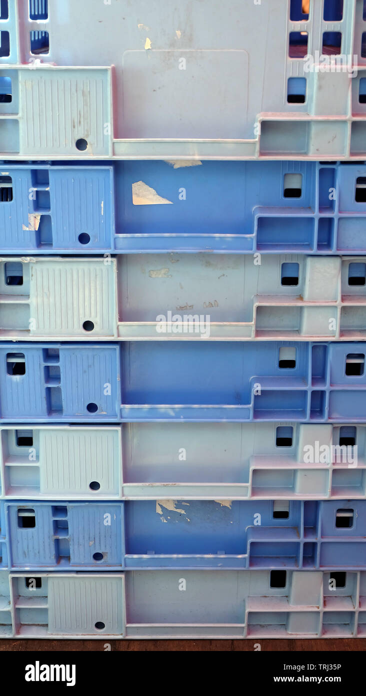Old agriculture plastic containers in faded color of blue, stacked ...