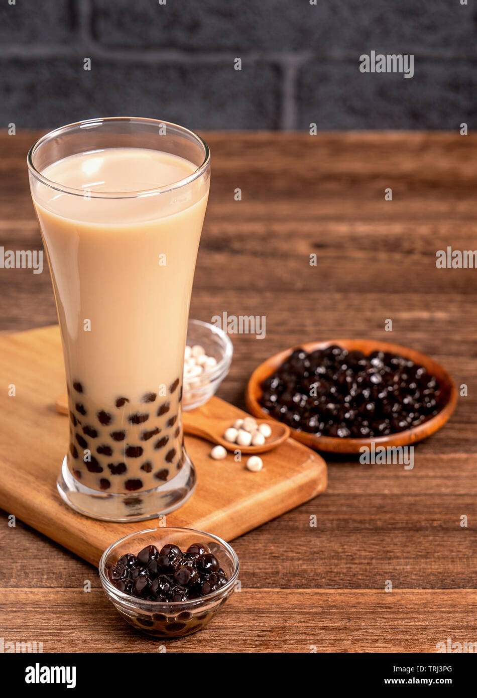 Delicious bubble milk tea with tapioca pearl ball in glass on wooden ...