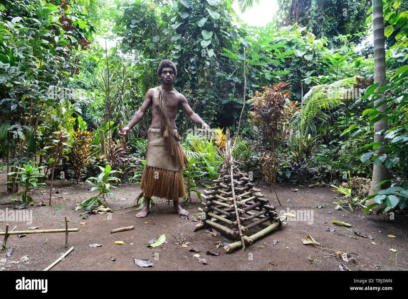 Young tribal man demonstrating how to use a wild chicken trap, Pepeyo ...